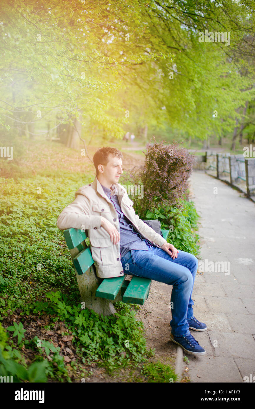 man sitting on bench in the park in spring time Stock Photo - Alamy