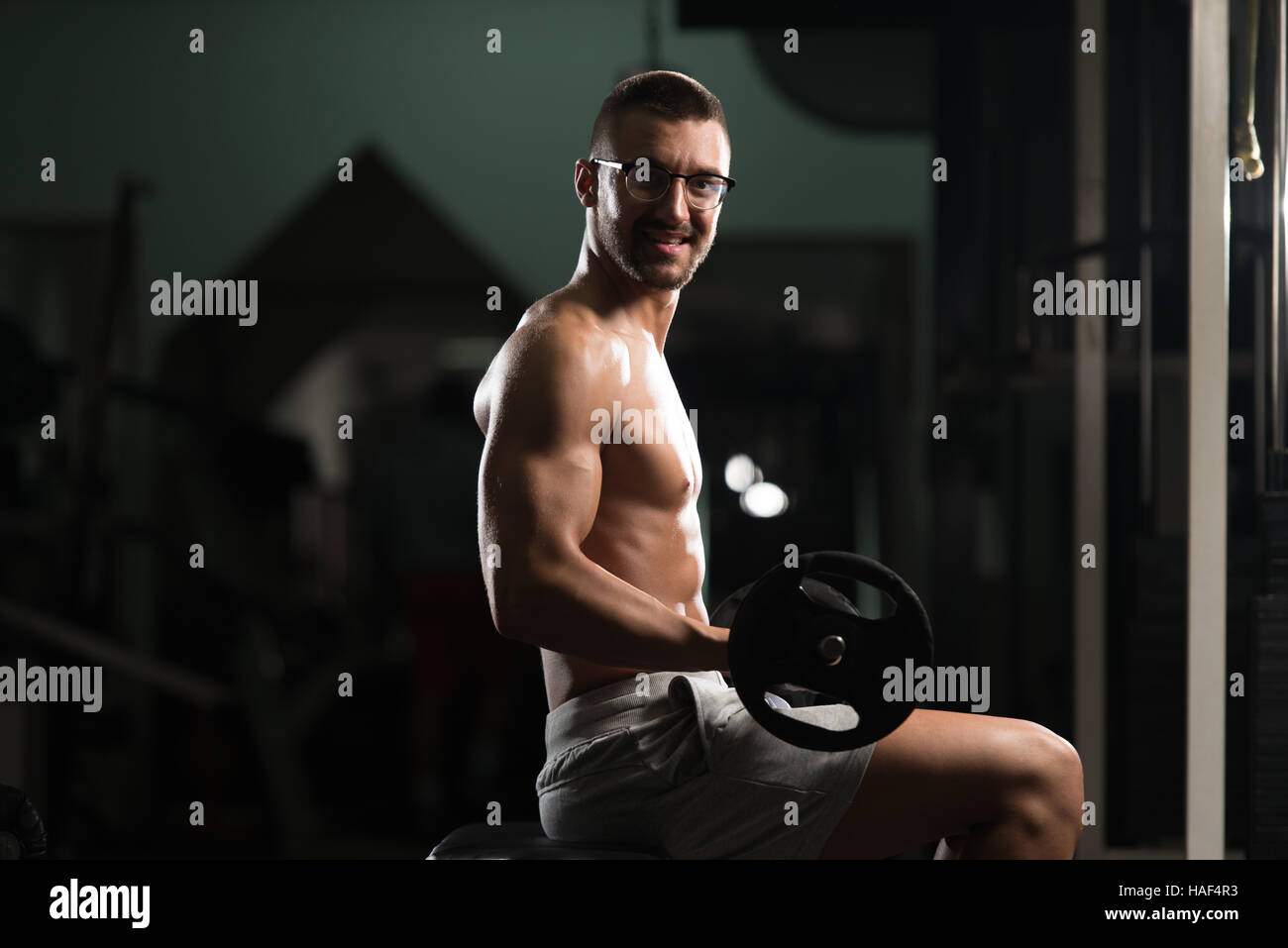 Muscular Nerd Man Doing Heavy Weight Exercise For Biceps With Barbell ...