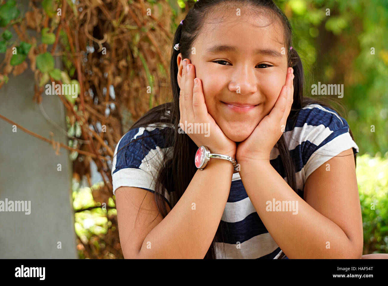 Young girl smiling with hands on cheeks, Pune, Maharashtra Stock Photo ...