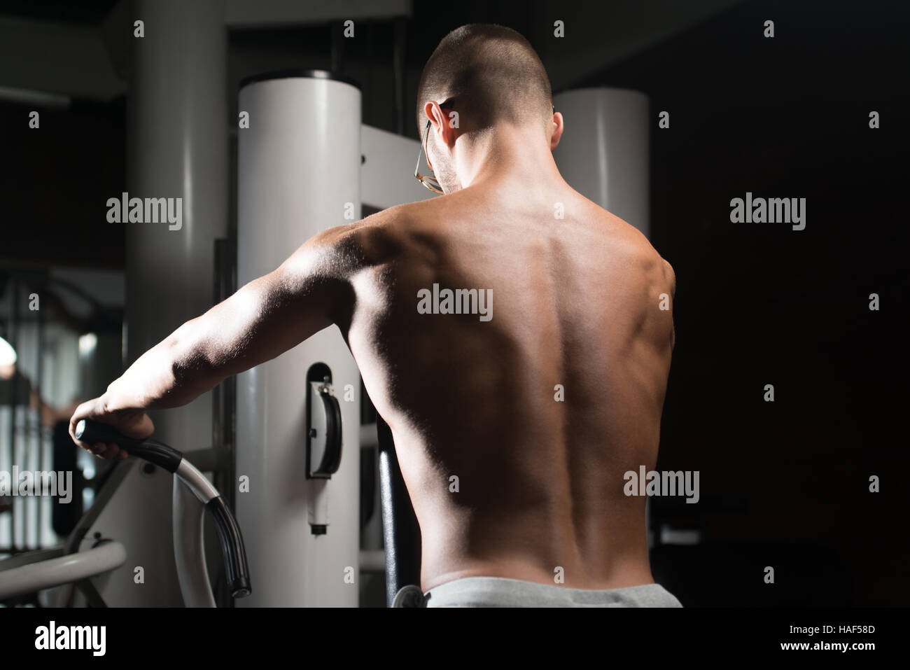 Handsome Bodybuilder Doing Heavy Weight Exercise For Back On Machine ...