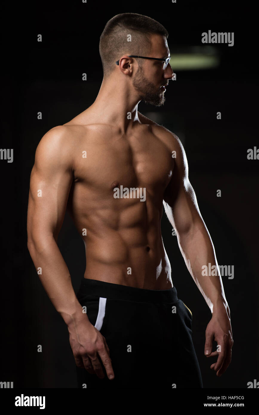 Handsome Geek Man Standing Strong In The Gym And Flexing Muscles ...