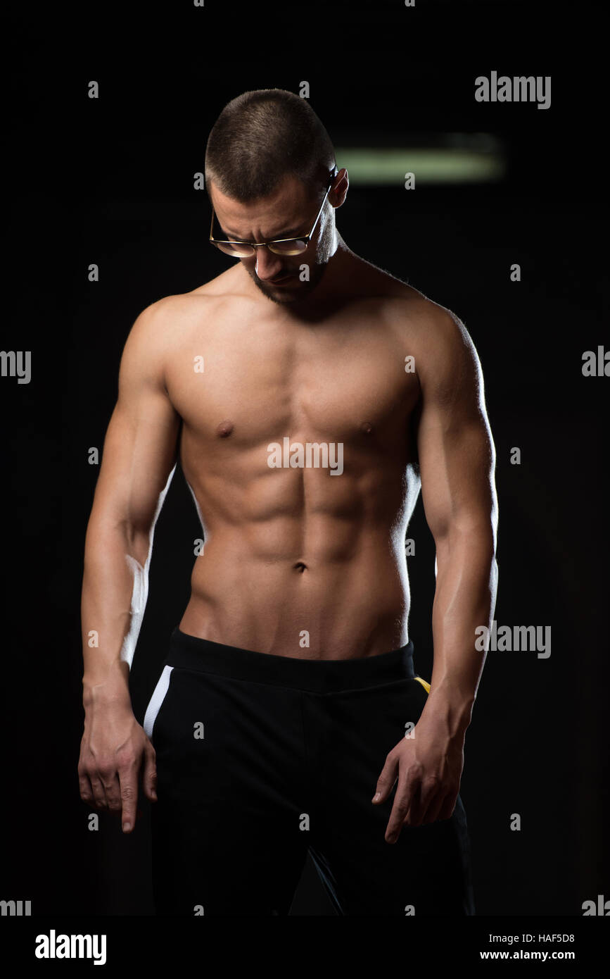 Handsome Geek Man Standing Strong In The Gym And Flexing Muscles ...