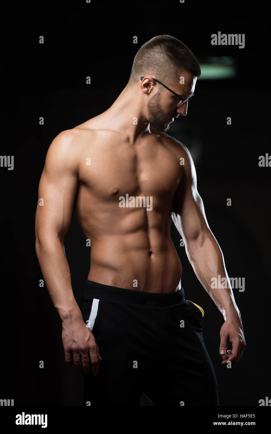 Handsome Geek Man Standing Strong In The Gym And Flexing Muscles ...