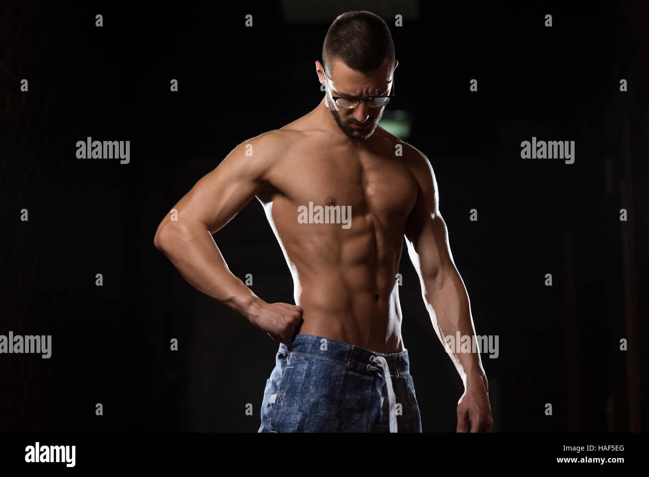 Handsome Geek Man Standing Strong In The Gym And Flexing Muscles ...
