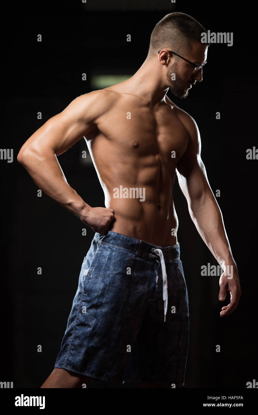 Handsome Geek Man Standing Strong In The Gym And Flexing Muscles ...