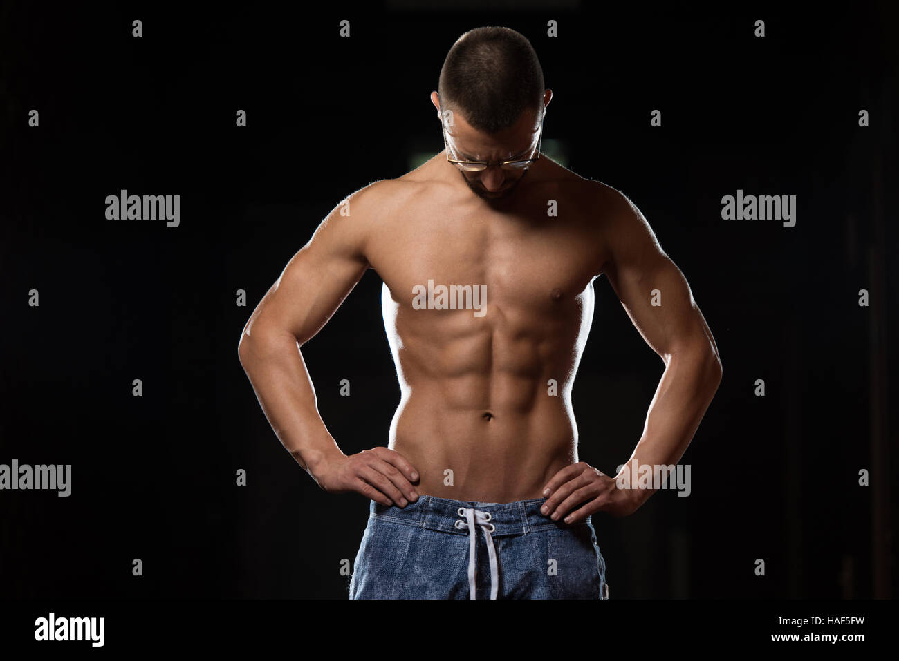 Handsome Geek Man Standing Strong In The Gym And Flexing Muscles ...