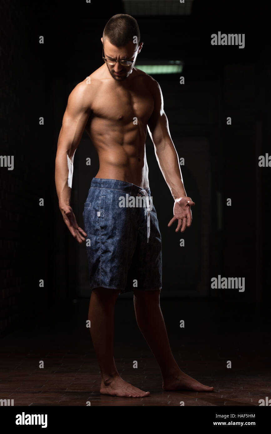 Handsome Geek Man Standing Strong In The Gym And Flexing Muscles ...