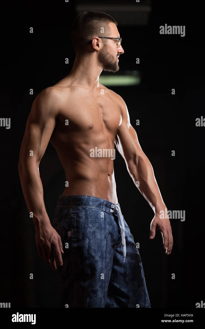 Handsome Geek Man Standing Strong In The Gym And Flexing Muscles ...