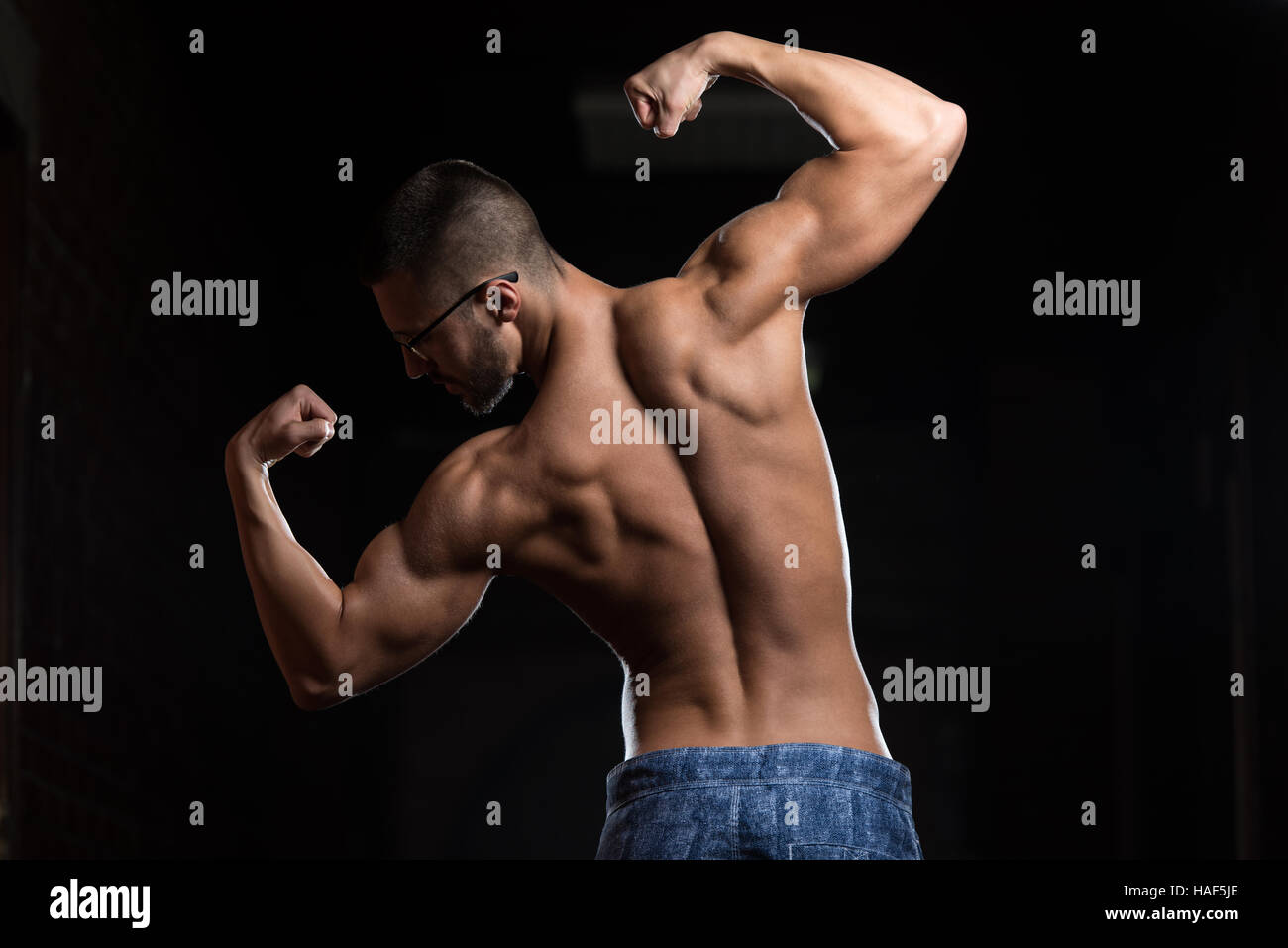 Handsome Geek Man Standing Strong In The Gym And Flexing Muscles ...