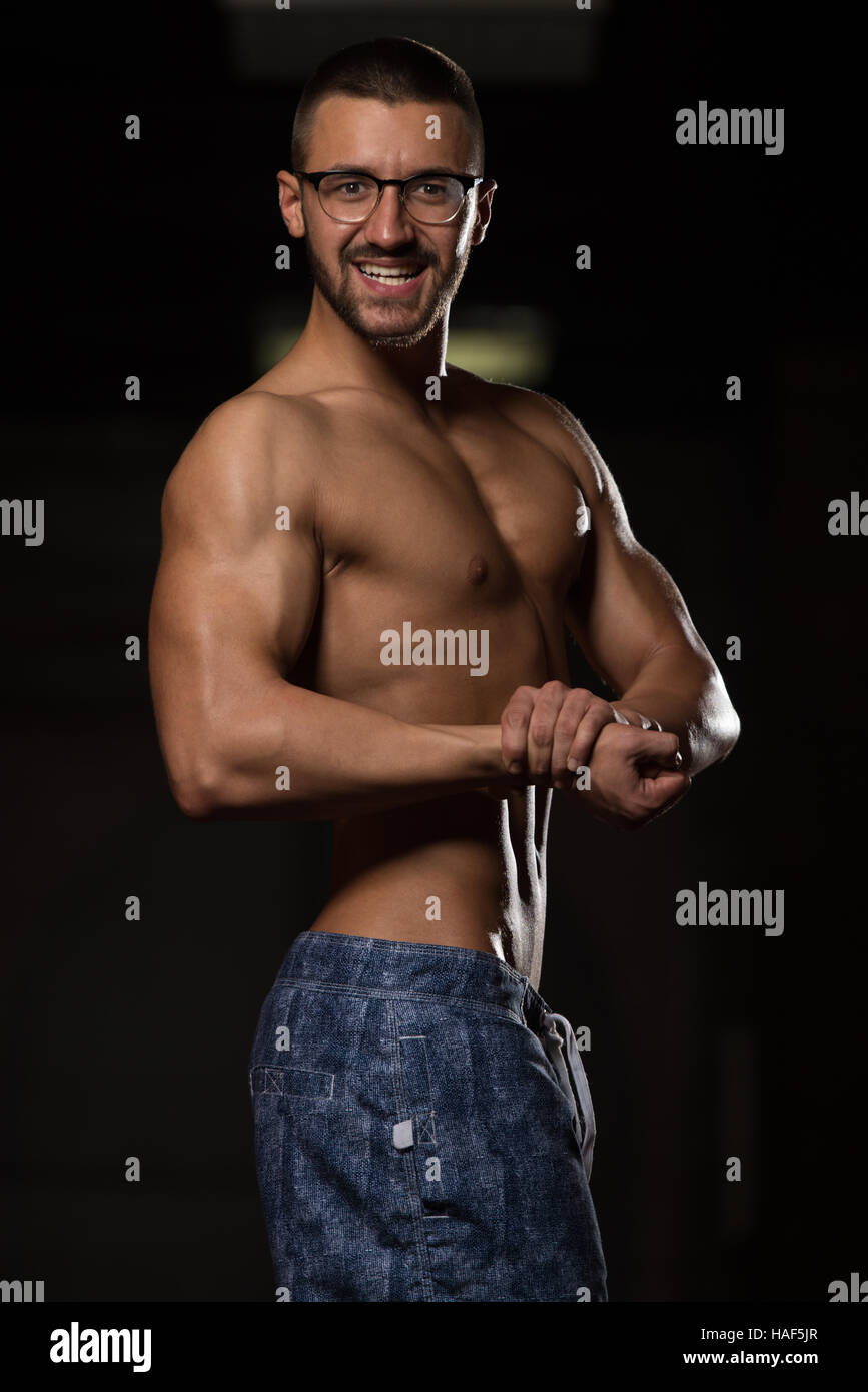 Handsome Geek Man Standing Strong In The Gym And Flexing Muscles ...