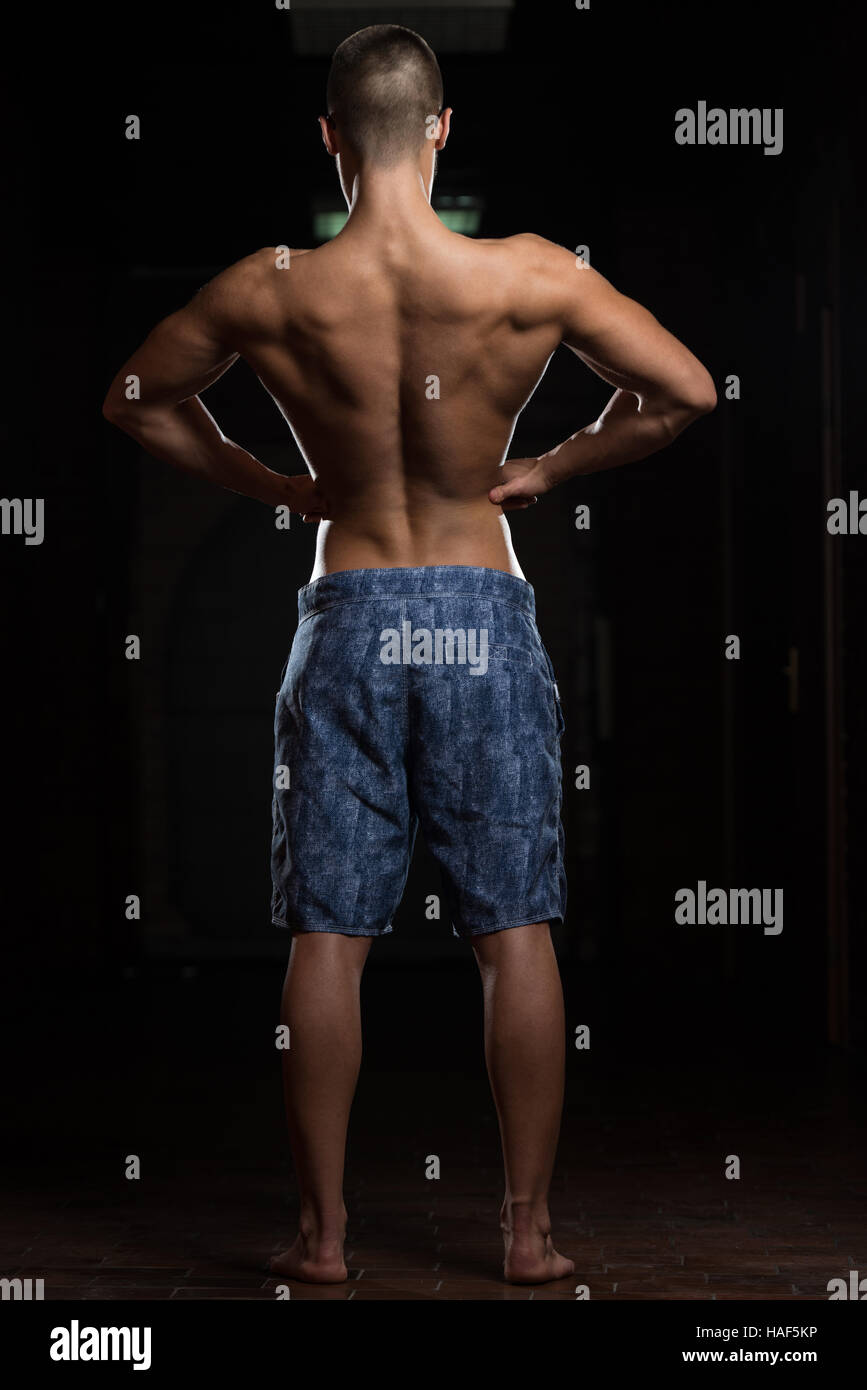 Handsome Geek Man Standing Strong In The Gym And Flexing Muscles ...