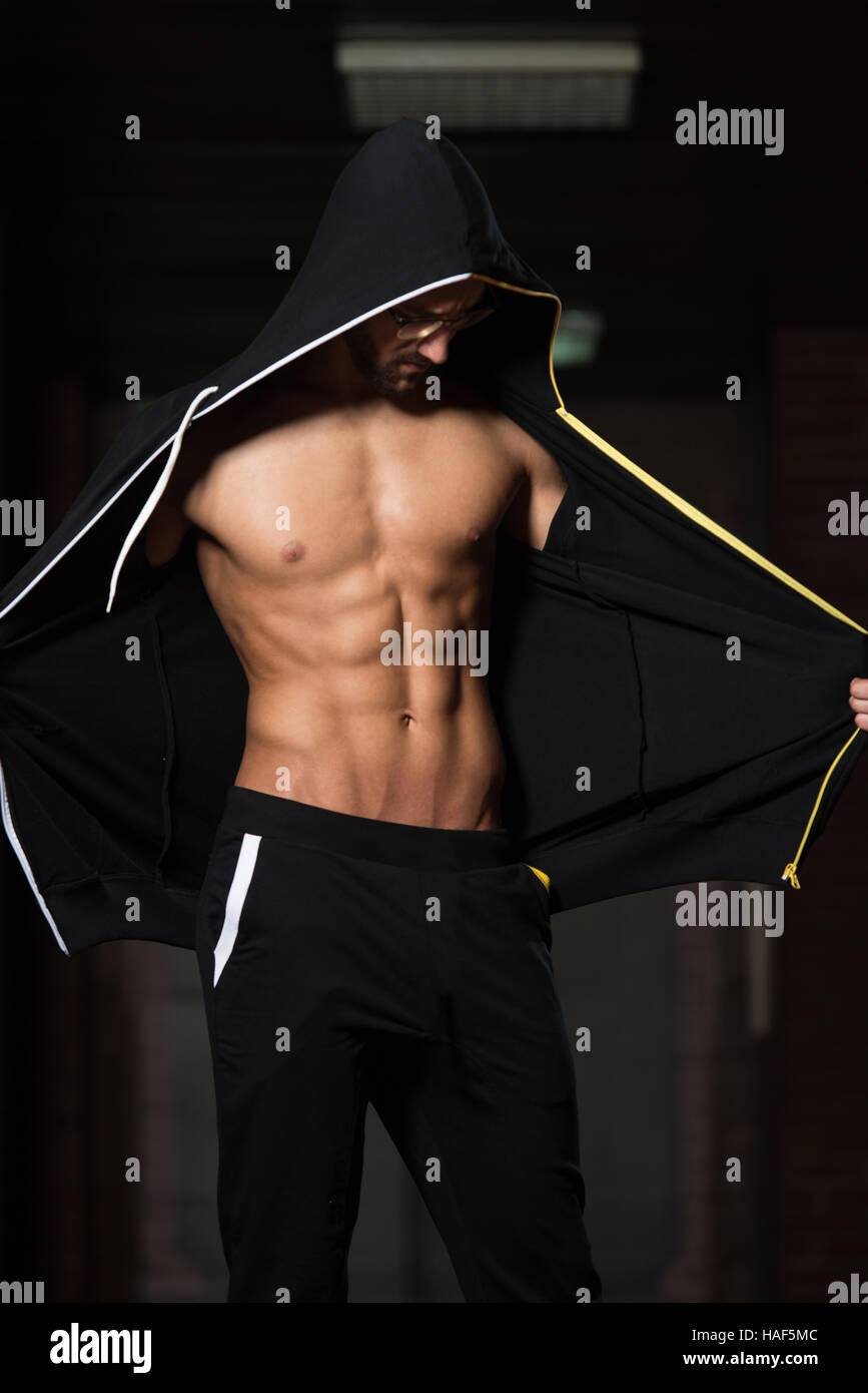 Handsome Geek Man Standing Strong In The Gym And Flexing Muscles ...