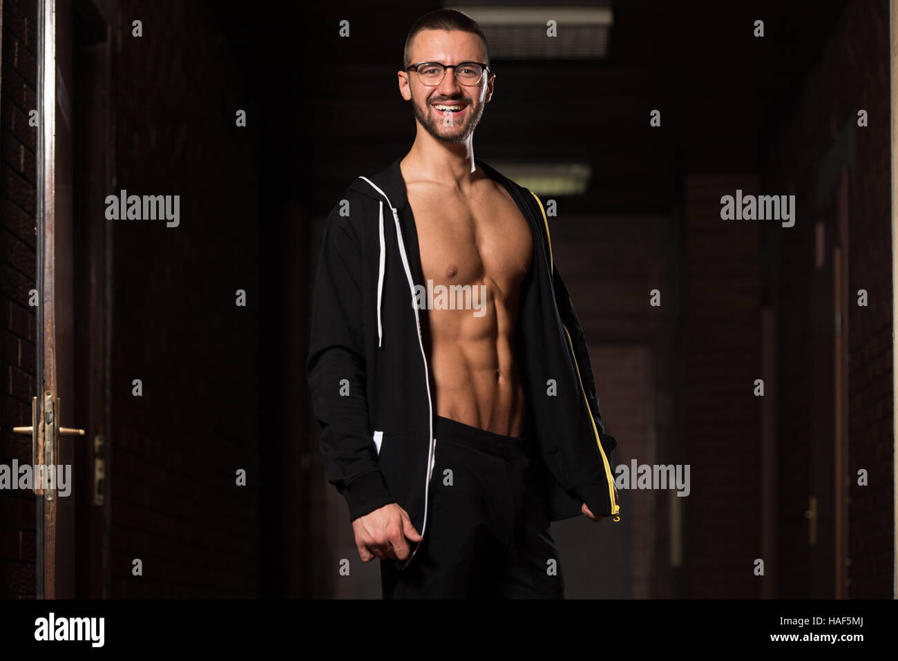 Handsome Geek Man Standing Strong In The Gym And Flexing Muscles ...