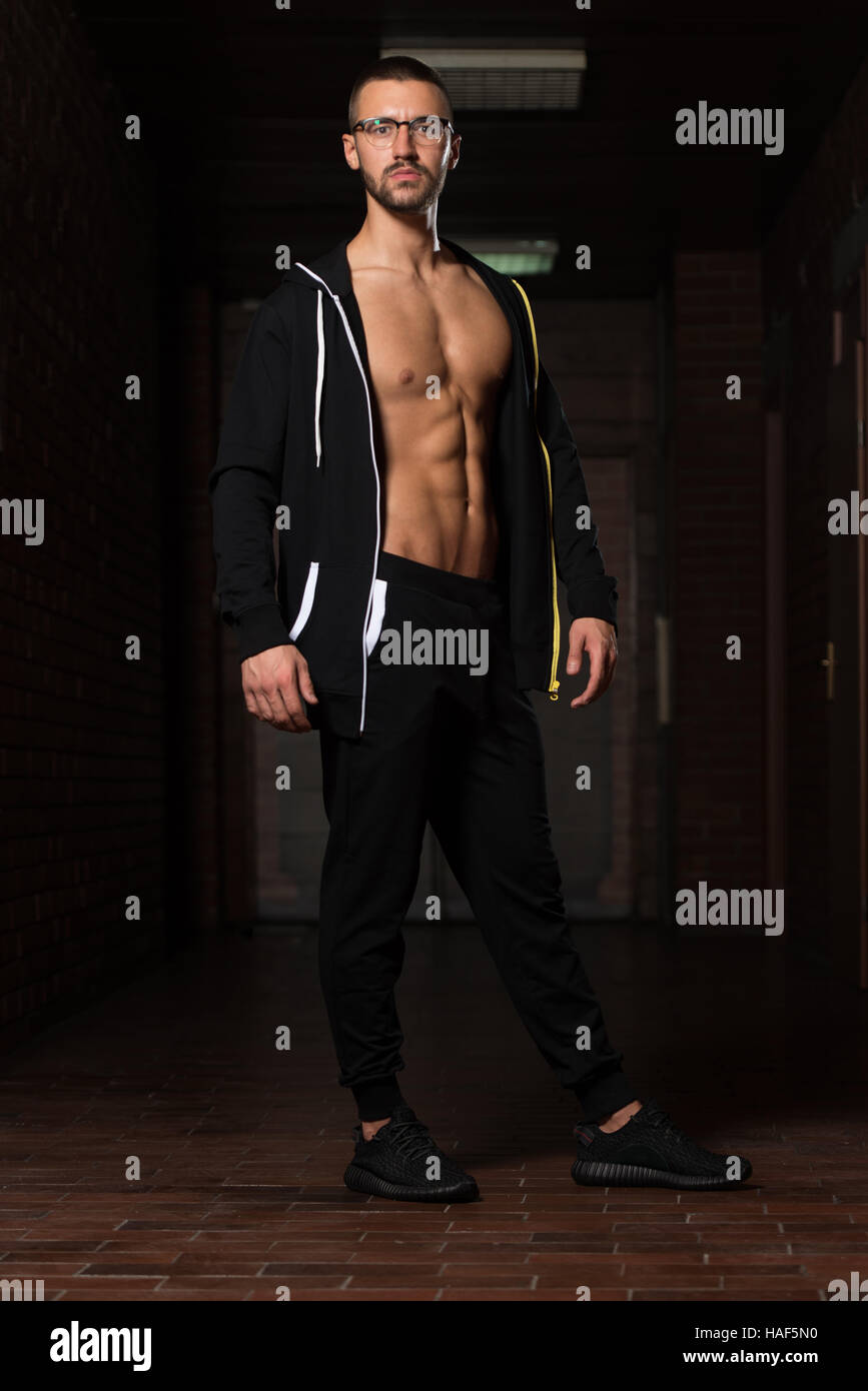 Handsome Geek Man Standing Strong In The Gym And Flexing Muscles ...