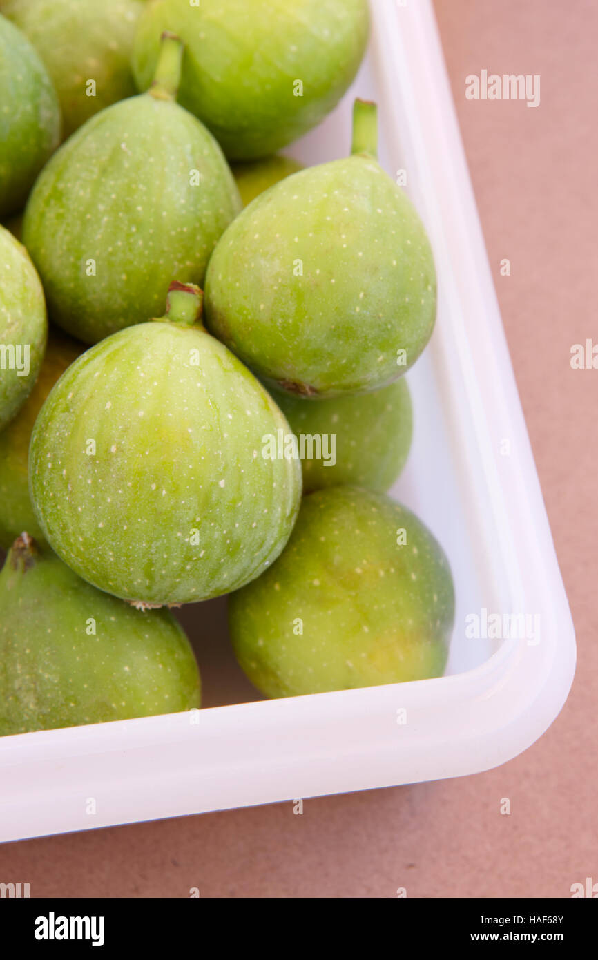 Fresh green figs on a plastic container detail. Vertical Stock Photo ...