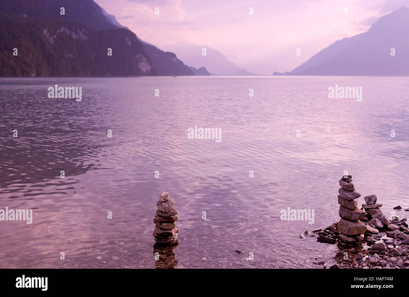swiss lake at sunset in brienz, Switzerland. Focus on the front rocks ...