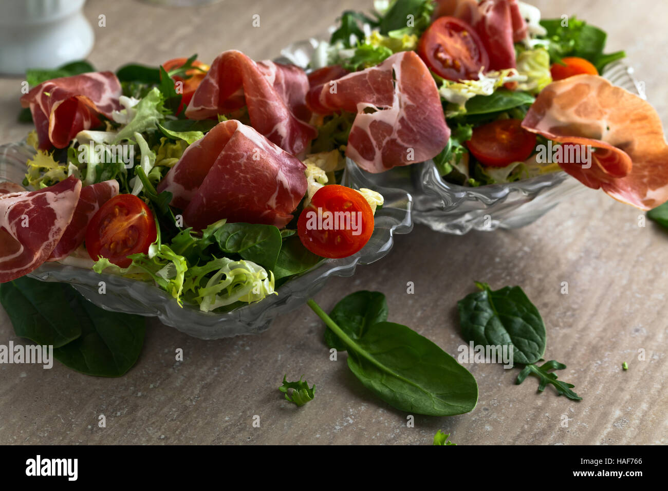 green salad with jamon on a kitchen table Stock Photo - Alamy