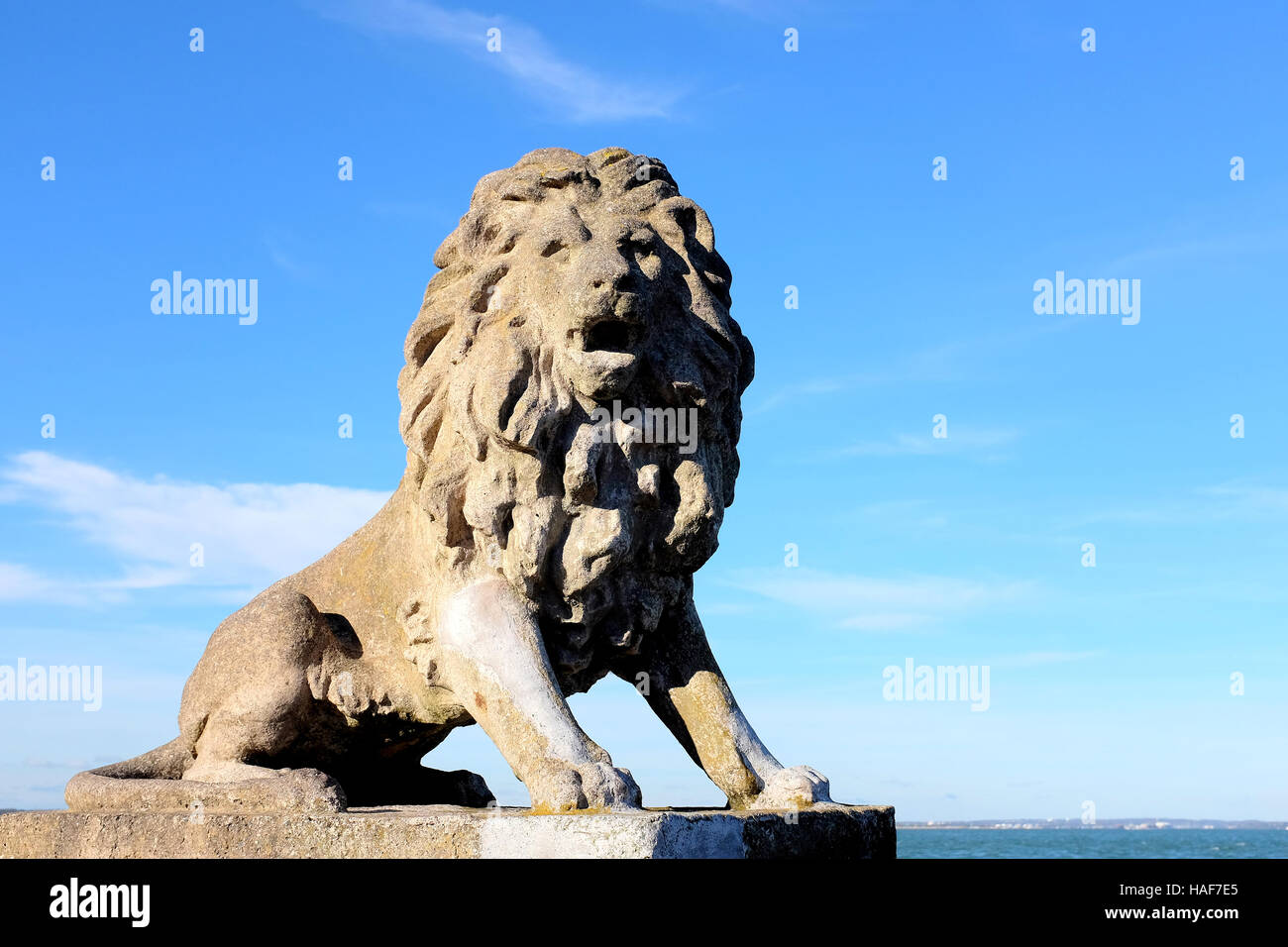 A weather beaten Lion statue overlooking the Solent on the banks at ...
