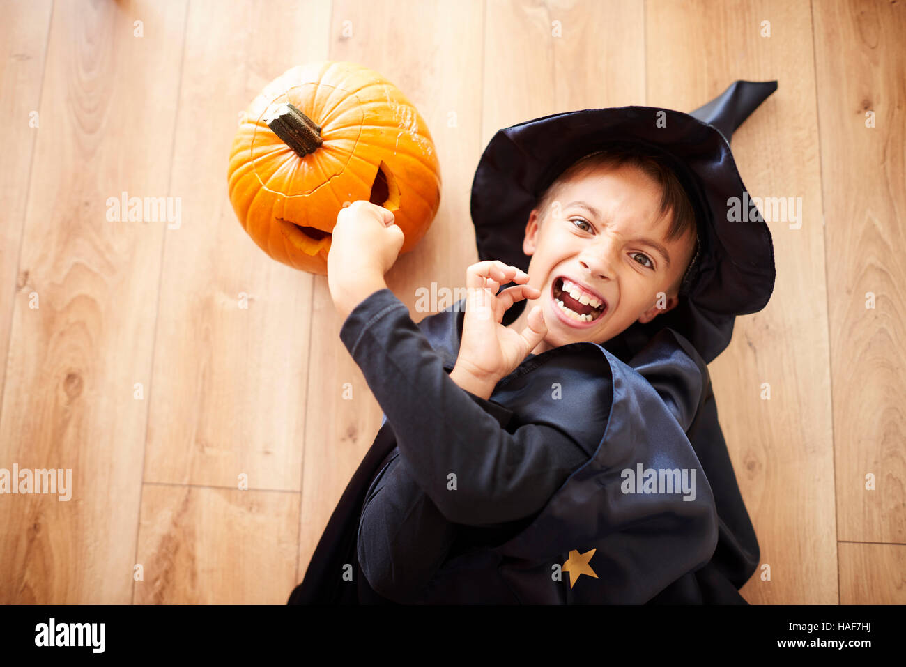 Little wizard on the floor with pumpkin Stock Photo - Alamy