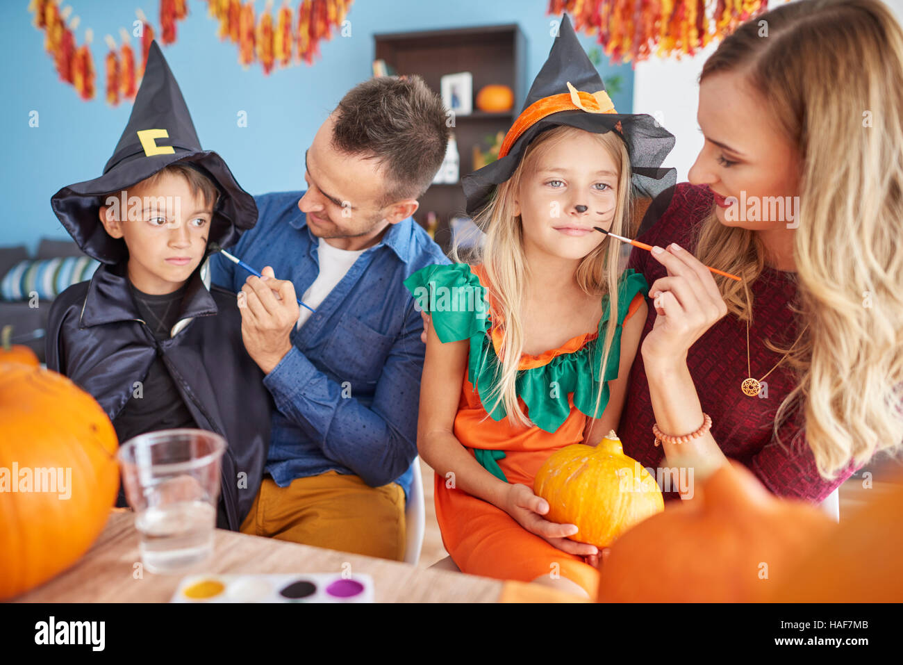 Parents painting on their offspring's faces Stock Photo - Alamy