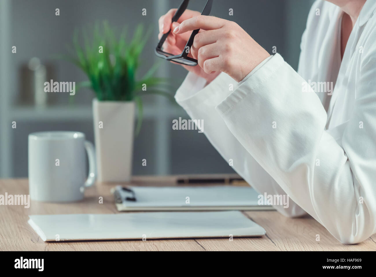 Female doctor reading patient medical history record in hospital office ...