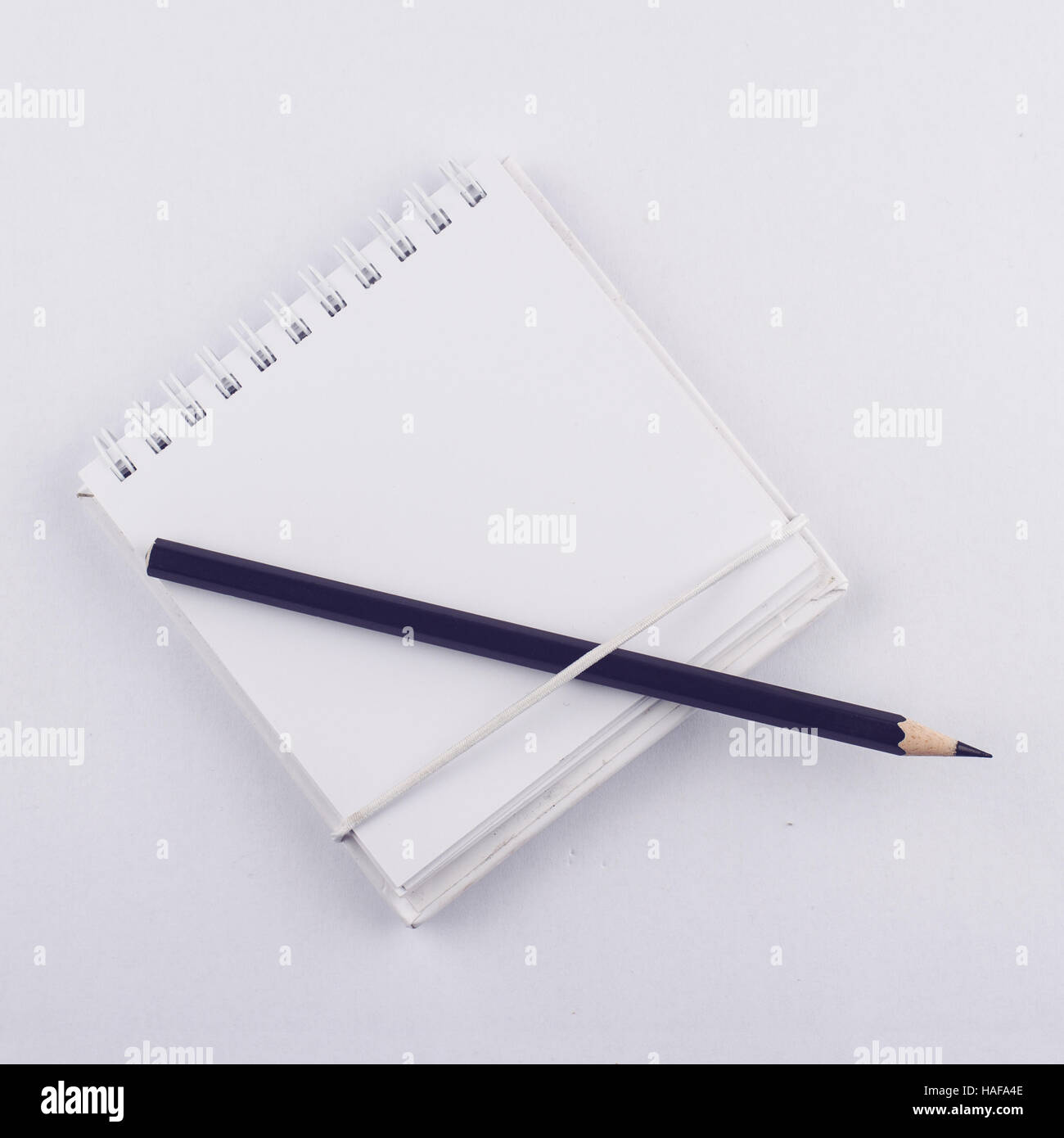 Front view of a white paper notebook with metallic spiral and a black ...