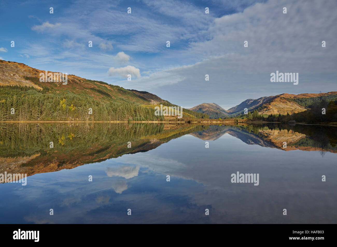 A loch in Scotland with the surrounding hills in the background ...