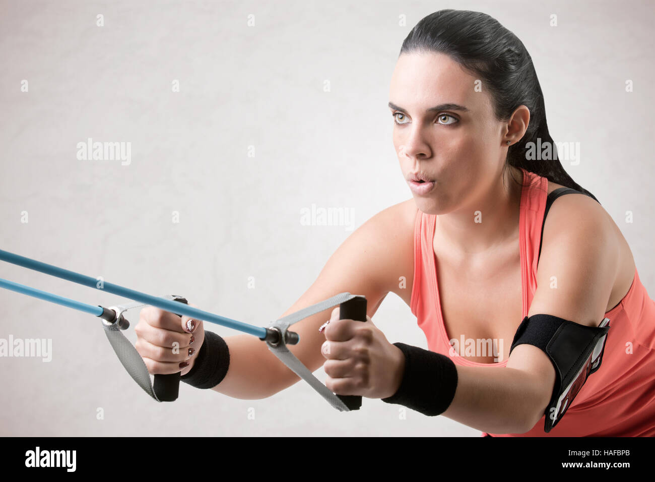 Fit woman working out with elastic bands, isolated in grey Stock Photo ...