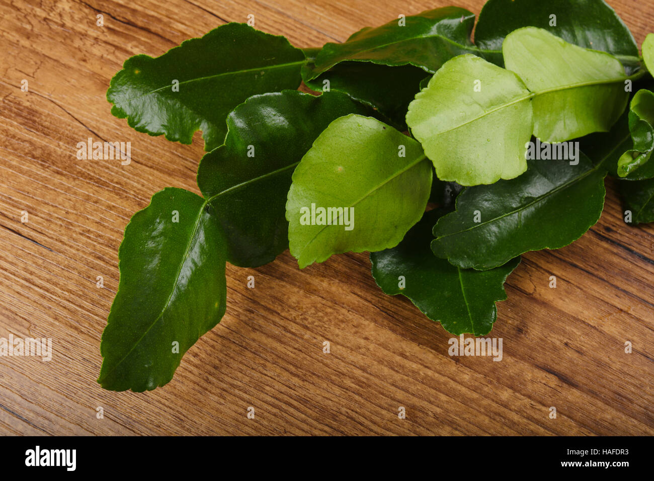 Kafir lime leaves on the wood background Stock Photo - Alamy