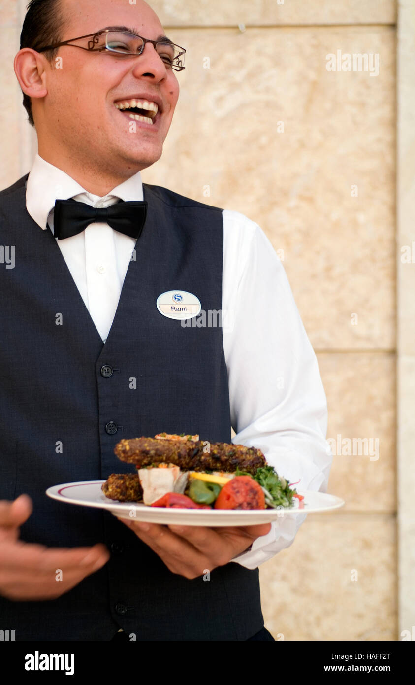 A waiter of the Sheraton in Aleppo, Syria, holding a plate with Kabbab ...