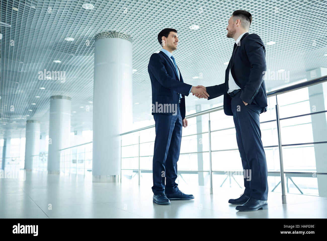 Two businessmen greeting one another by handshake Stock Photo - Alamy