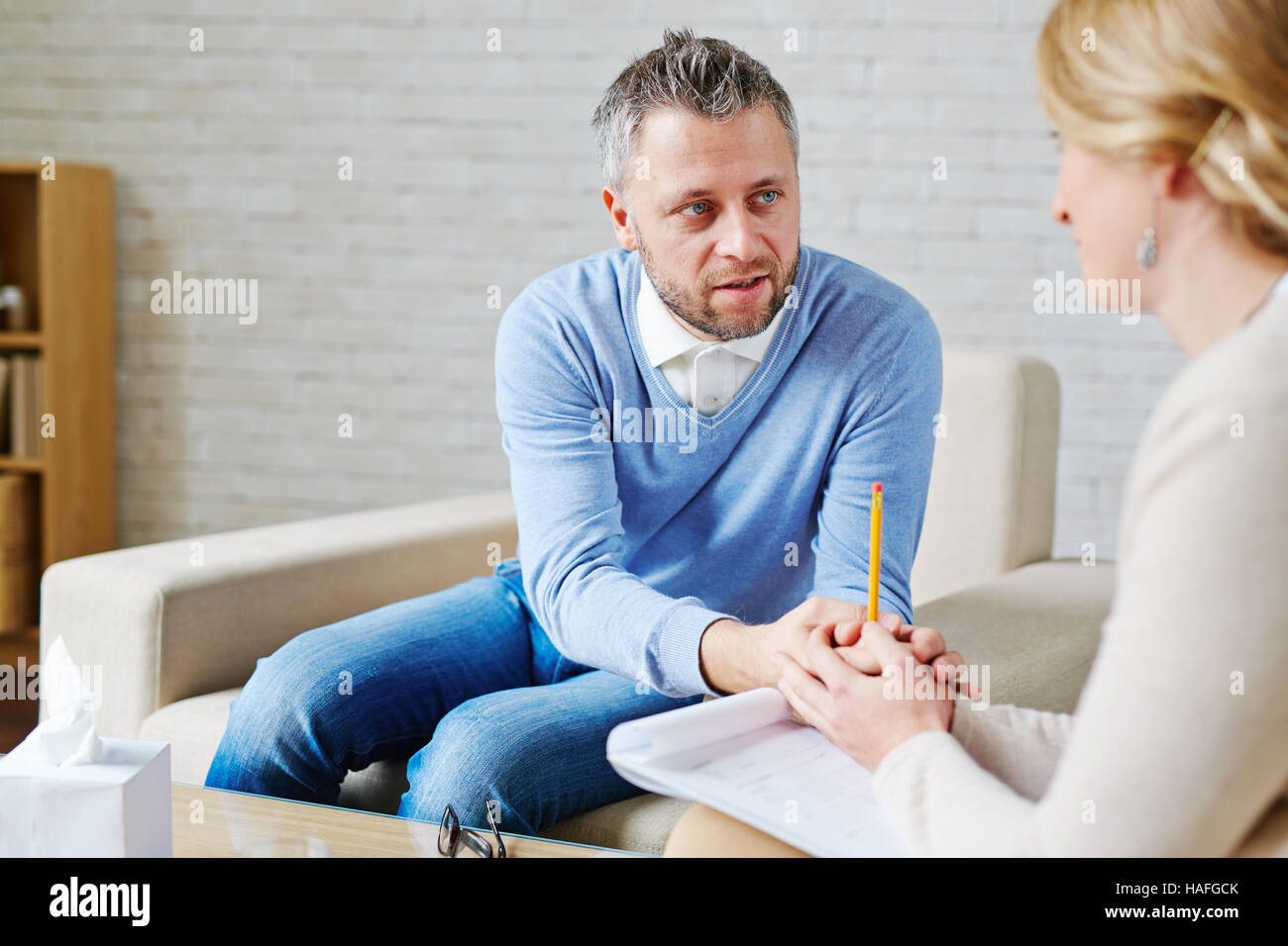 Man expressing empathy to young woman during psychological session ...