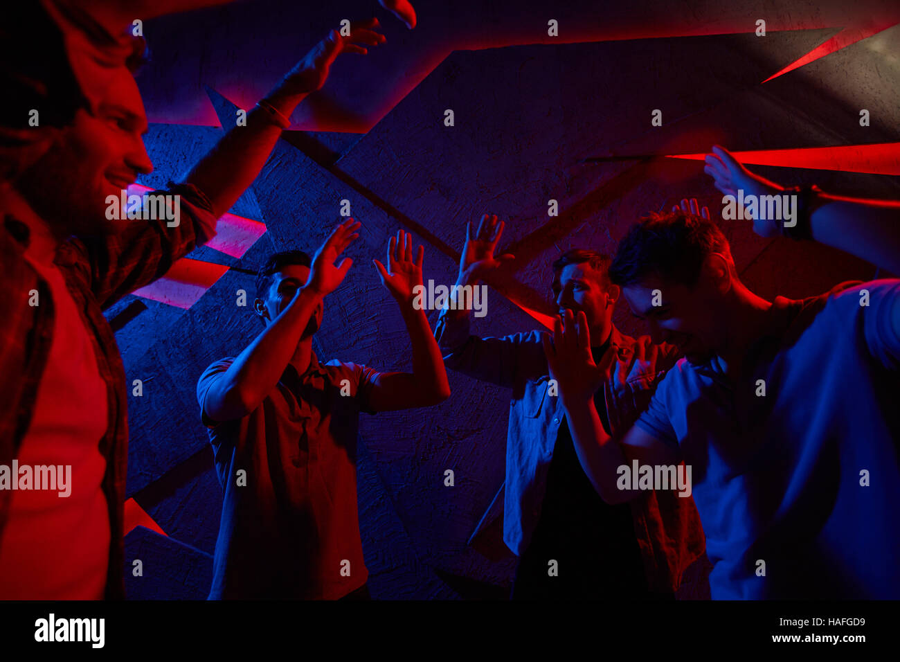 Group of ecstatic guys dancing in night club Stock Photo - Alamy