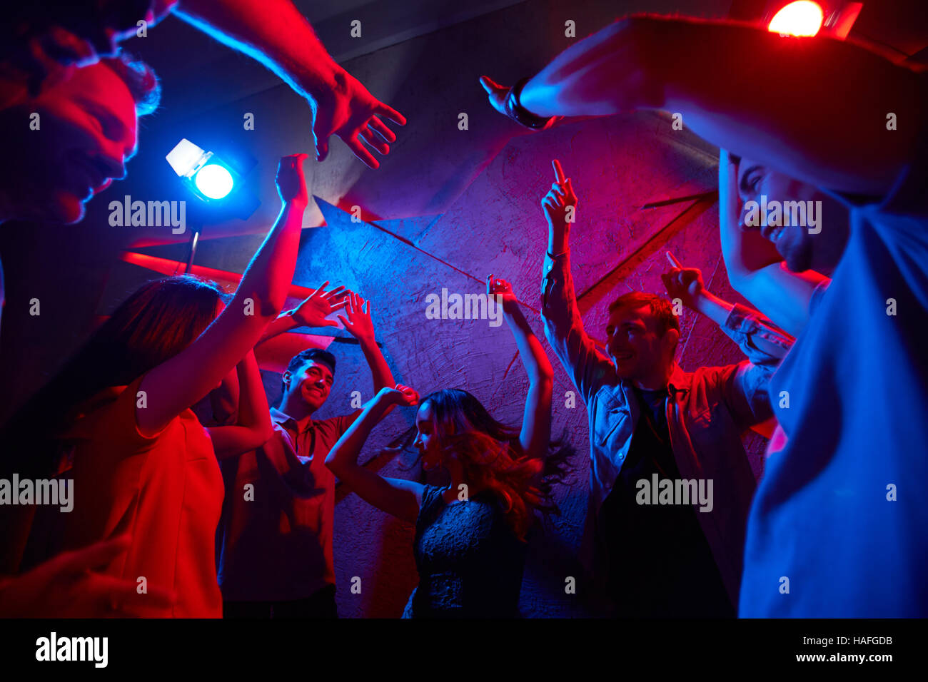 Dancing friends with raised hands dancing in night club Stock Photo - Alamy