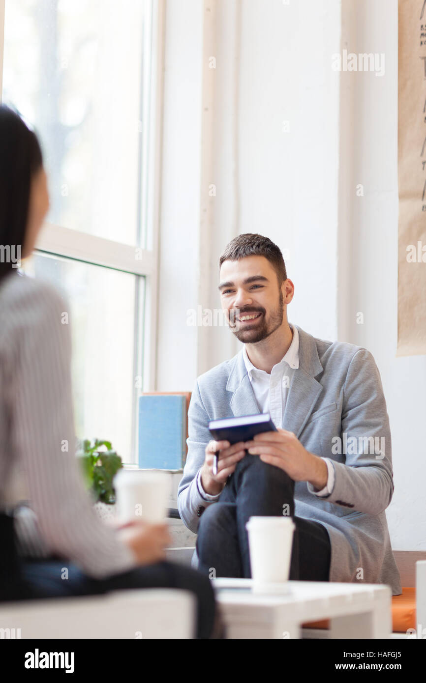 Happy entrepreneur listening to colleague during talk at break Stock ...