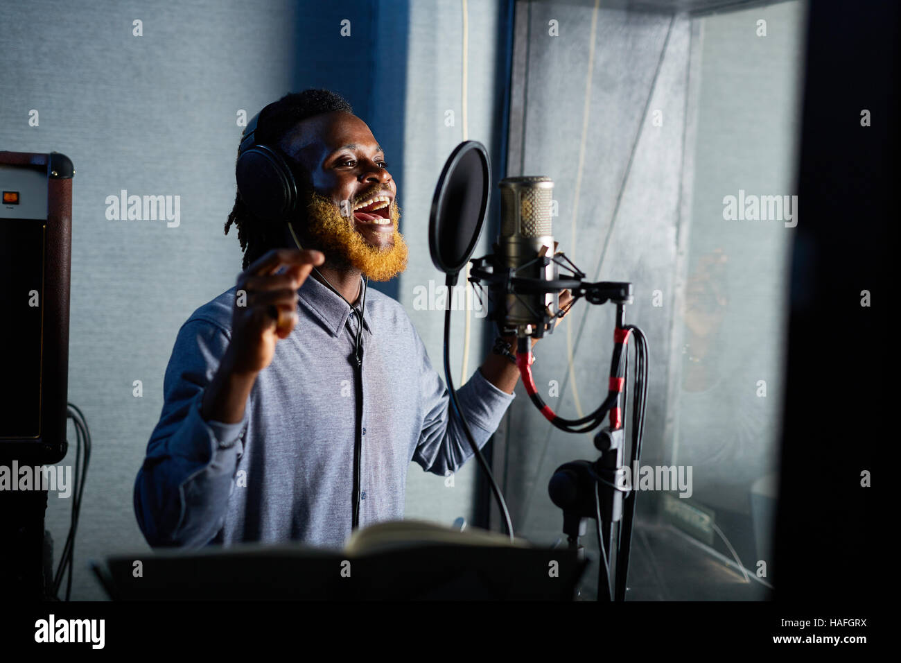 Young vocalist singing in mike in studio of recording Stock Photo - Alamy
