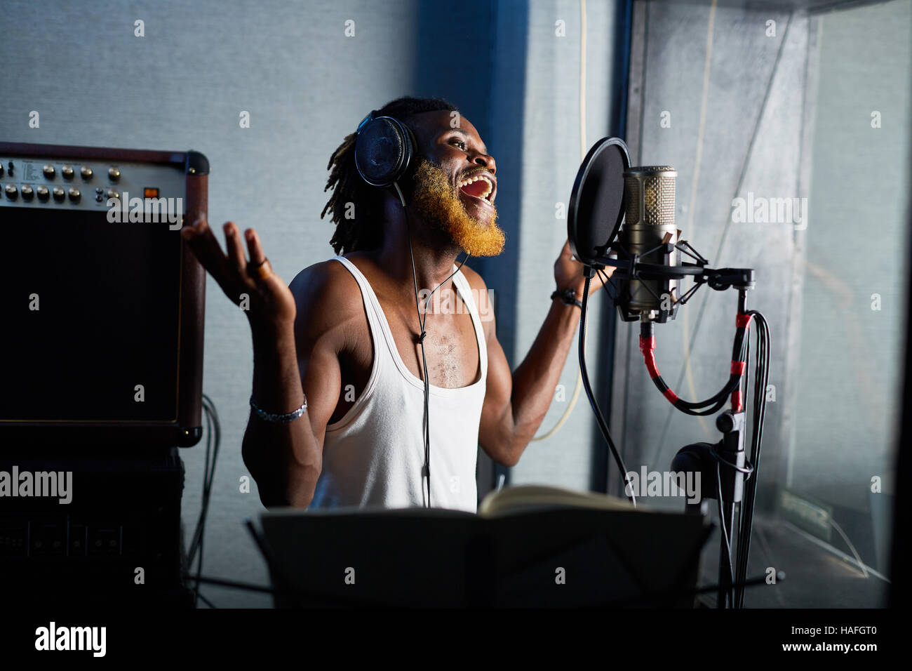 Happy young performer singing and recording songs Stock Photo - Alamy