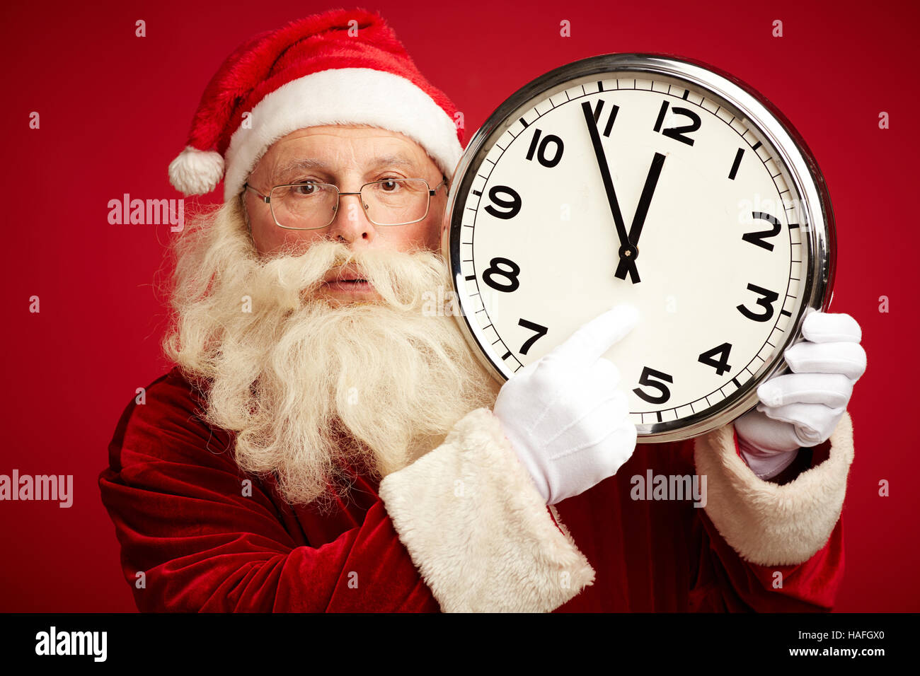 Santa Claus pointing at face of clock showing five minutes to midnight ...