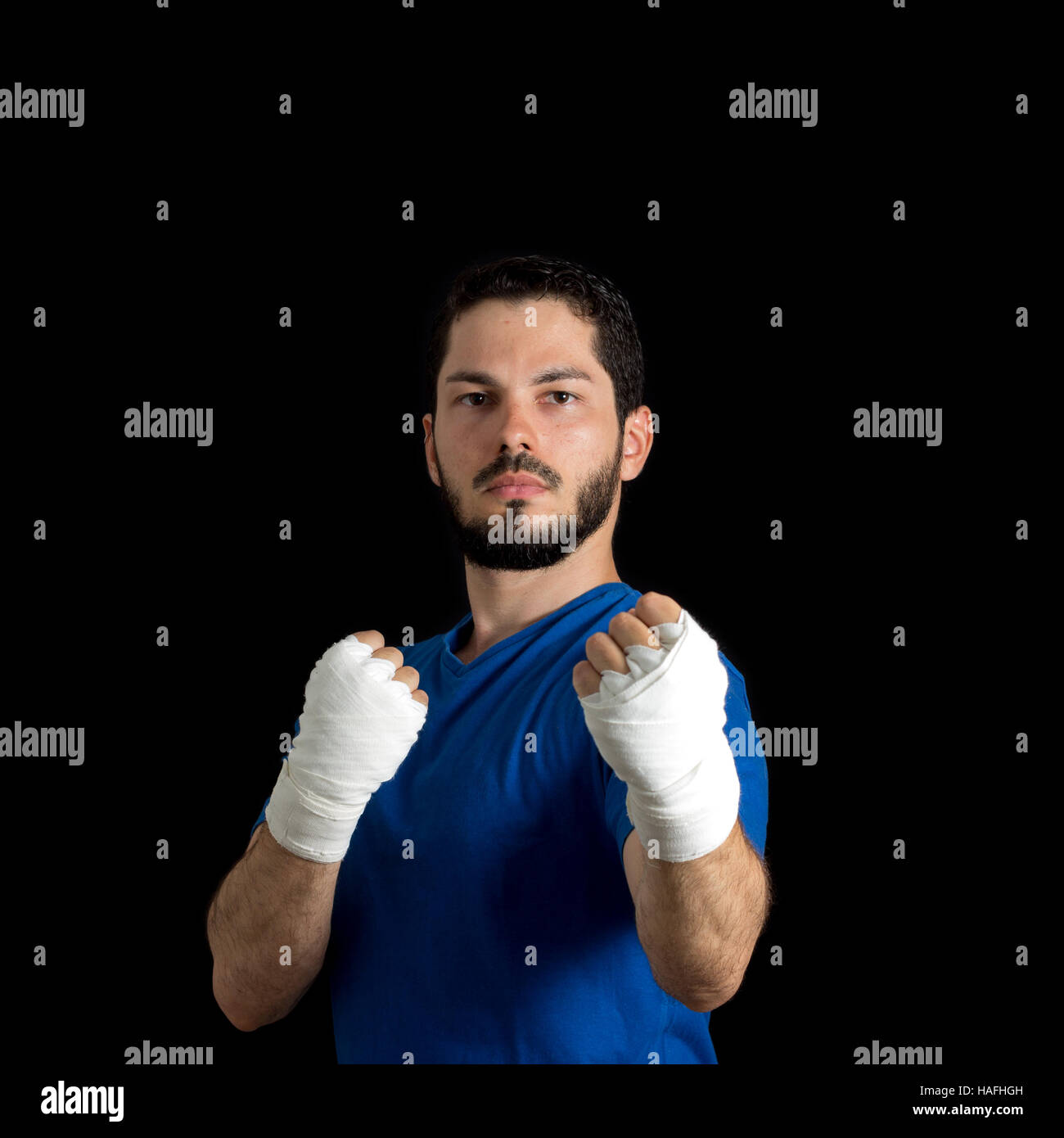 Black background and male in guard position. wearing white hand straps ...