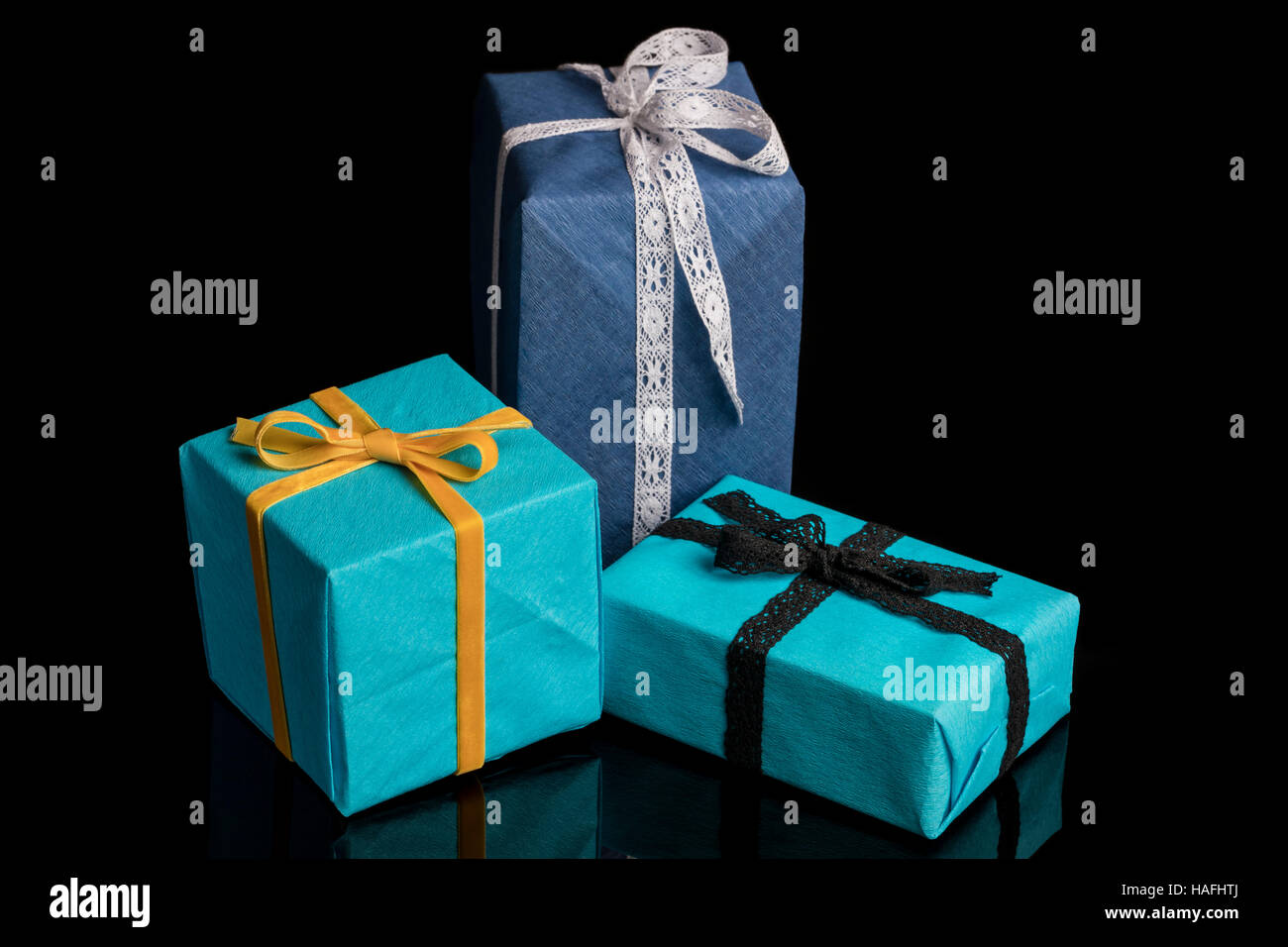 Three presents of different sizes wrapped in blue and turquoise ...