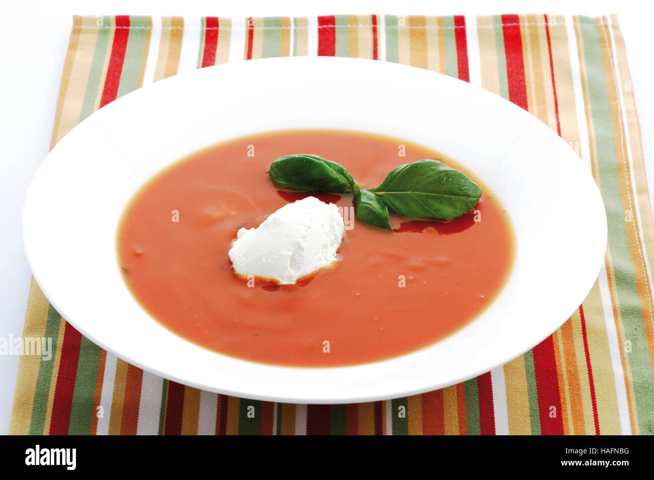Tomato soup topped with cream dollop Stock Photo - Alamy