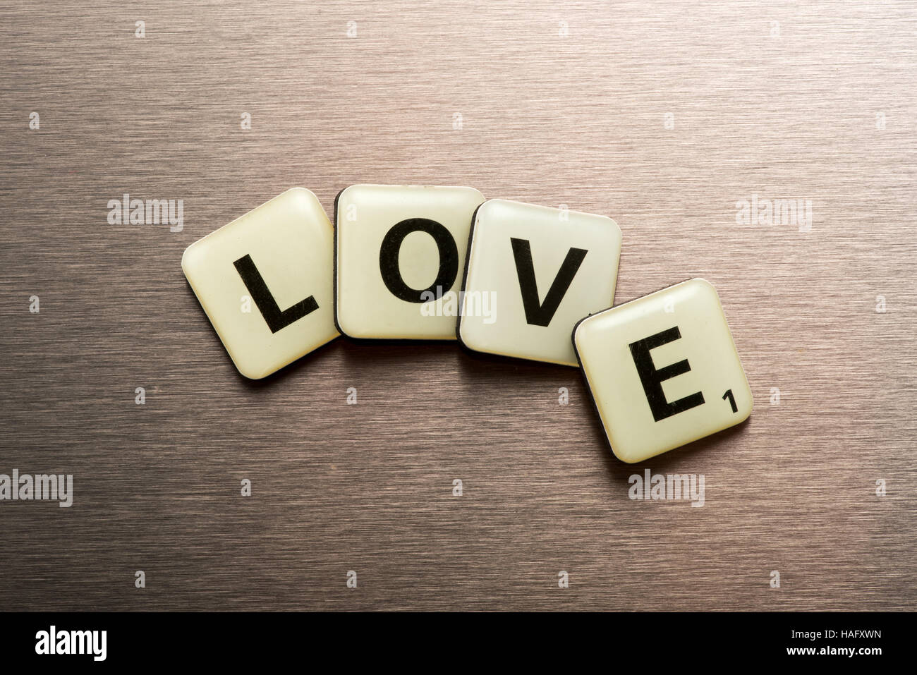 Word Love on letter blocks arranged in a curve on a textured metal ...