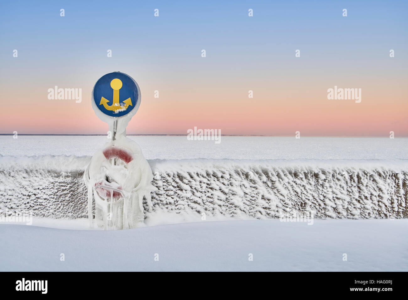 Frozen life buoy with icicles at a port i the winter by a frozen sea ...