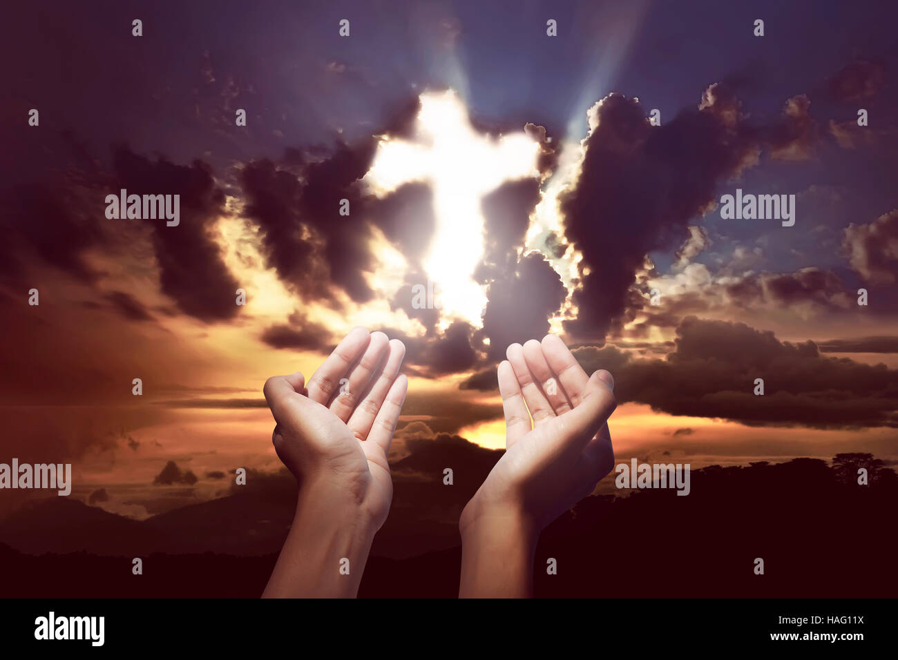 Human hands praying over the cross over sky background Stock Photo - Alamy
