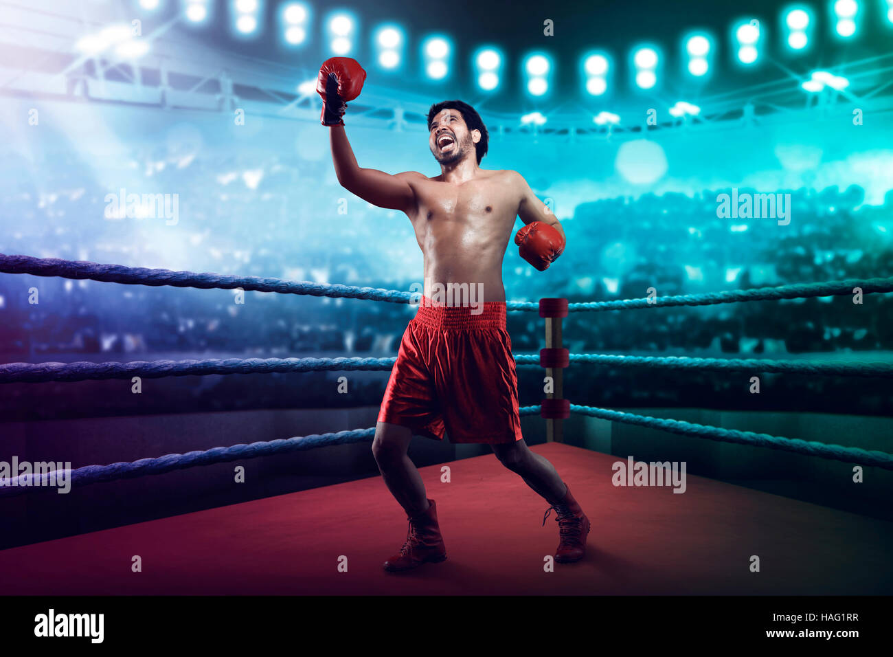 Muscular asian male boxer throwing an uppercut with dramatic expression ...
