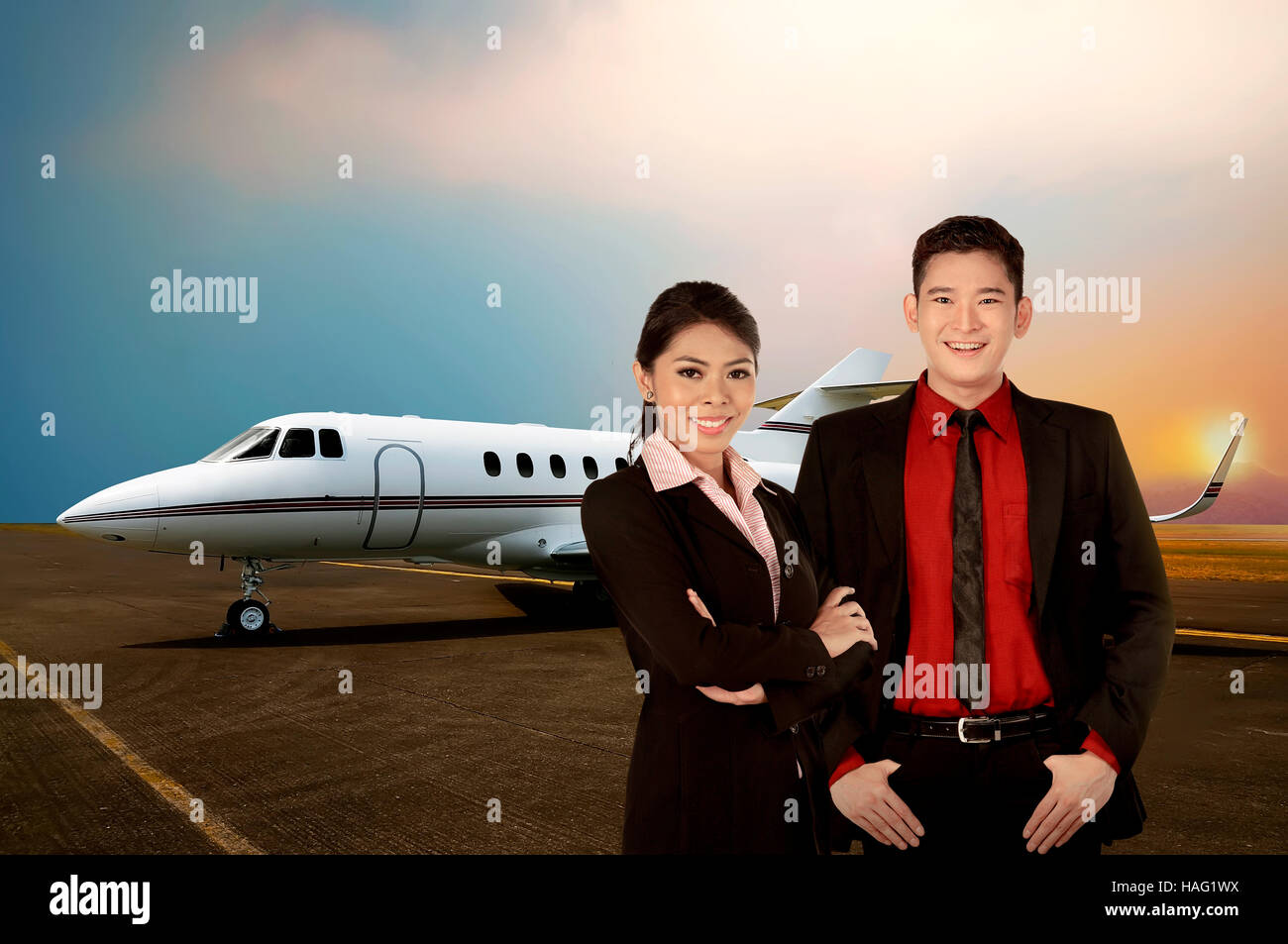 Business man and woman smiling in front of private jet. Business travel ...