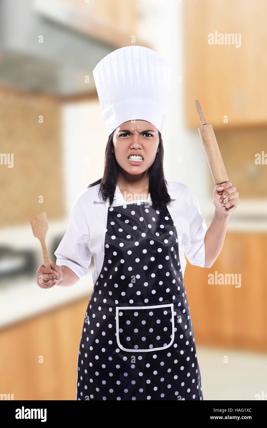 Portrait of young woman chef over kitchen background Stock Photo - Alamy