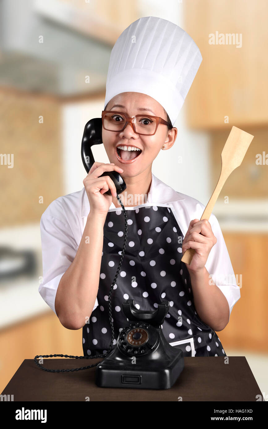 Portrait of young woman chef phone over kitchen background Stock Photo ...