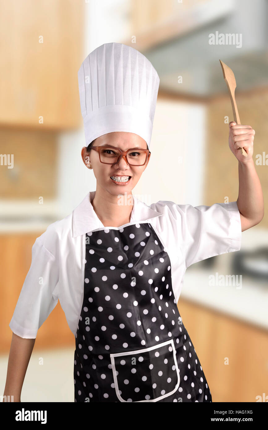 Portrait of young woman chef over kitchen background Stock Photo - Alamy