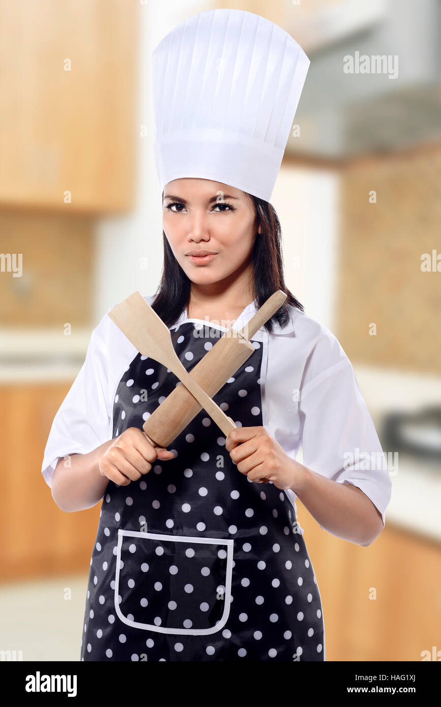 Portrait of young woman chef over kitchen background Stock Photo - Alamy
